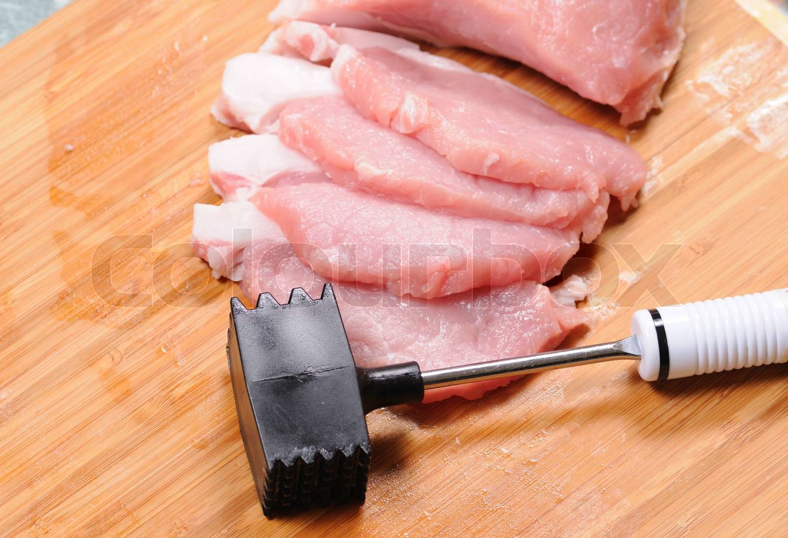 The cook prepares a chop from pork | Stock image | Colourbox