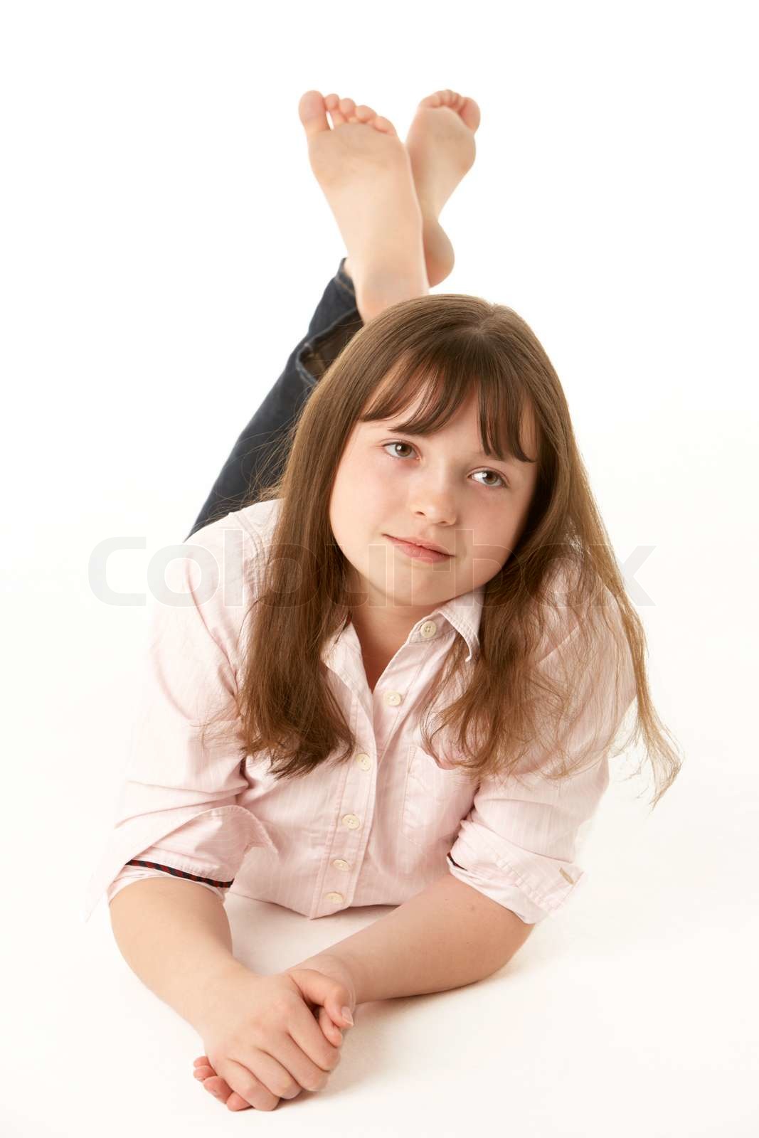 Thoughtful Young Girl Lying On Stomach In Studio | Stock image | Colourbox