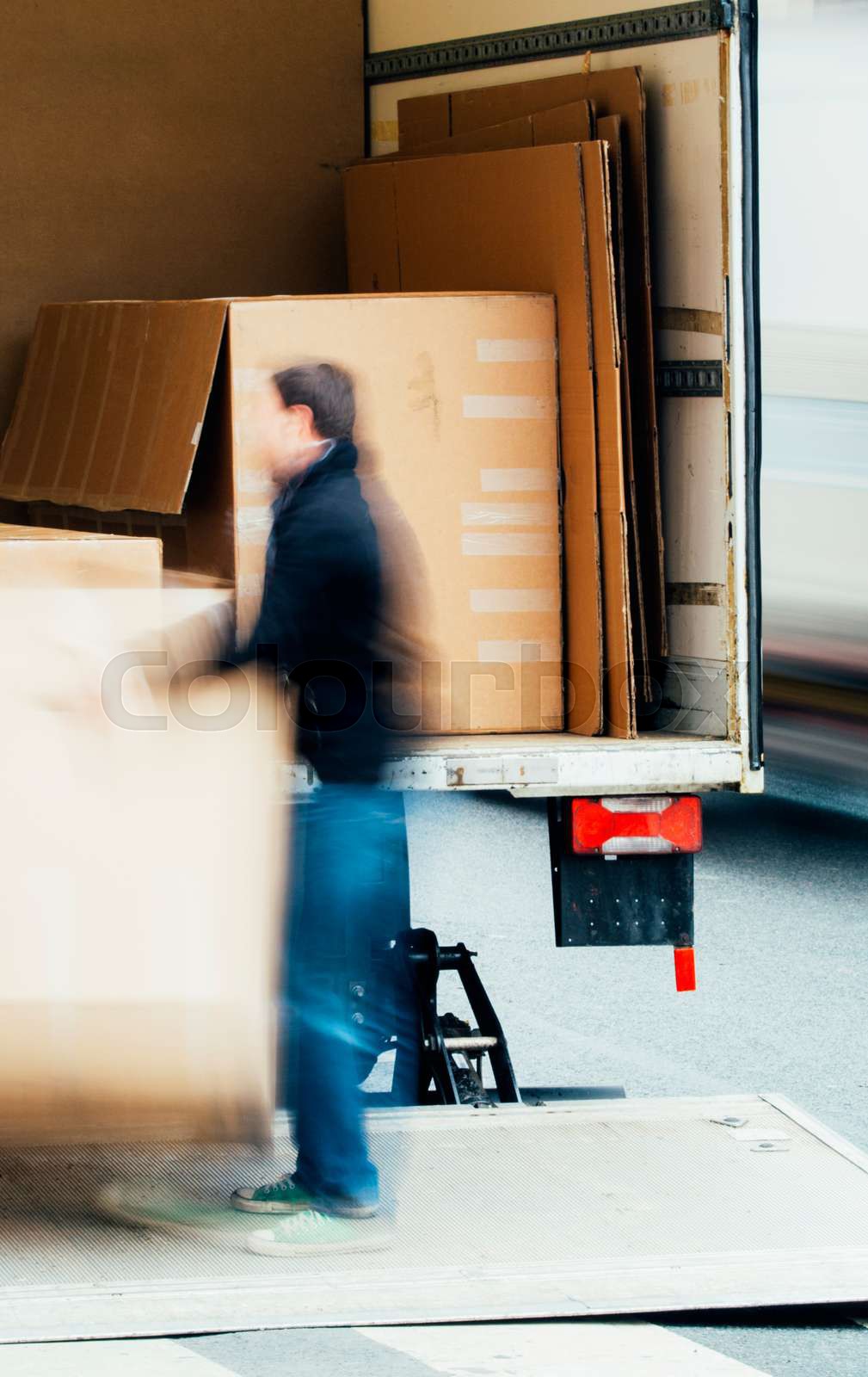 Man unloading boxes from a truck | Stock image | Colourbox