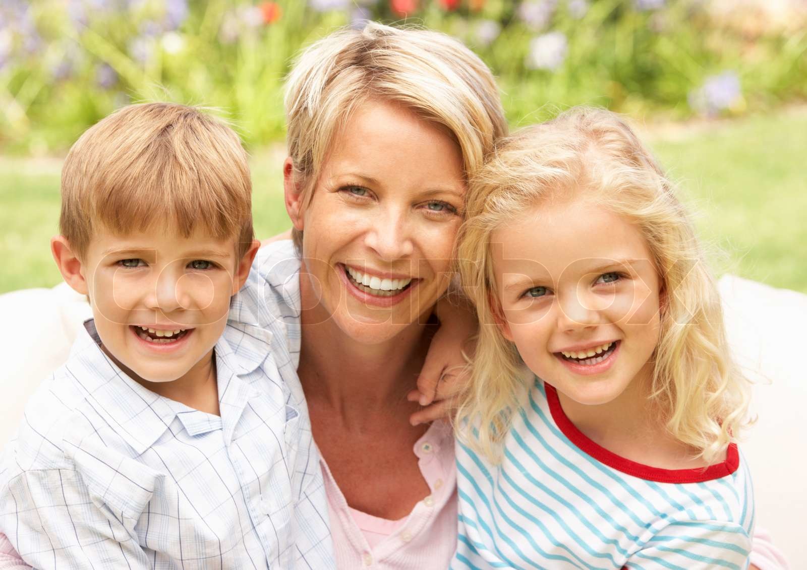 Mutter und Kinder Entspannen im Garten | Stock Bild | Colourbox