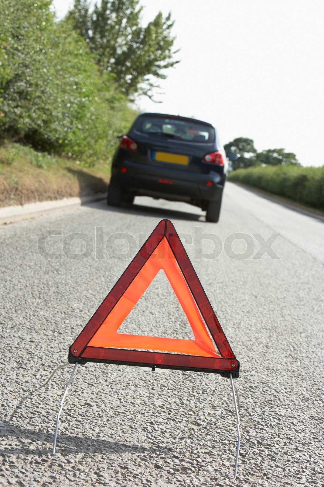 Car Broken Down On Country Road With Hazard Warning Sign In Foreground ...