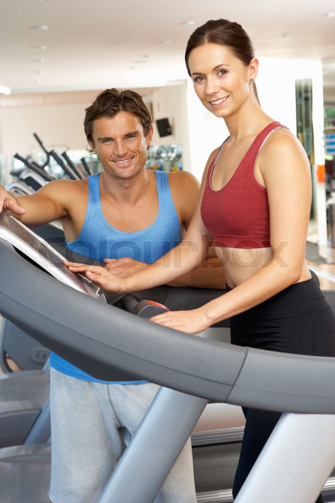 Frau, Arbeiten mit Personal Trainer On Running Machine Im Gym | Stock ...