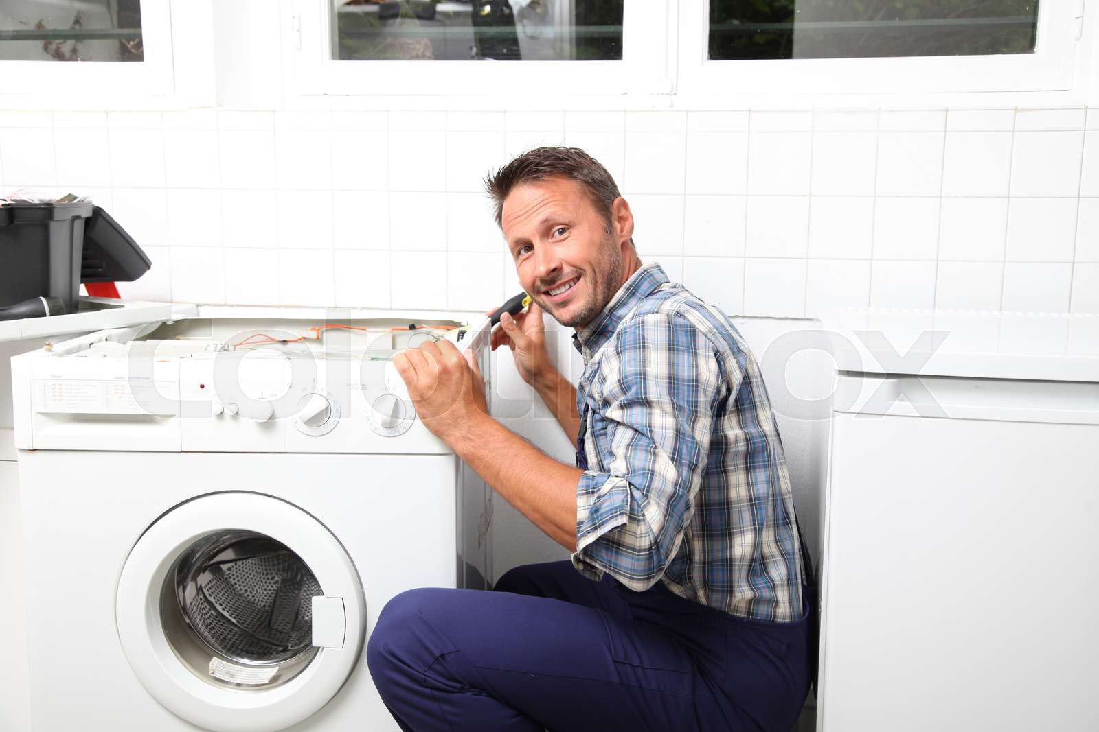 Fixing a washing machine | Stock image | Colourbox