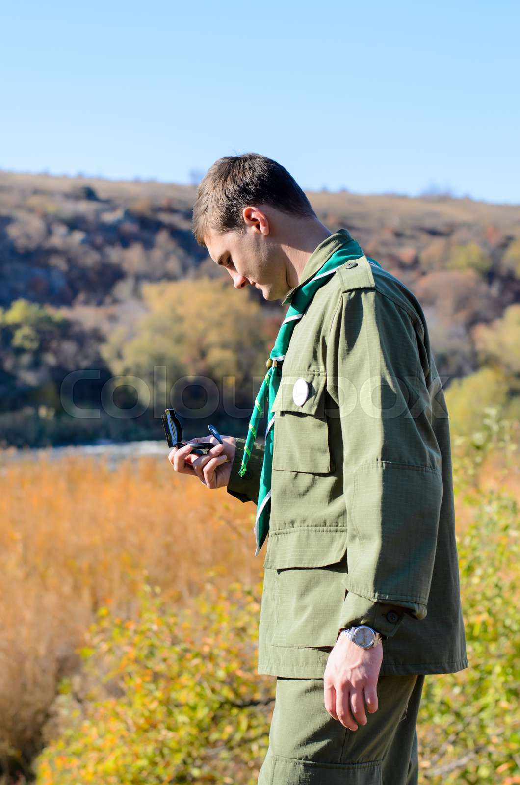 Scout master reading a compass outdoors | Stock image | Colourbox