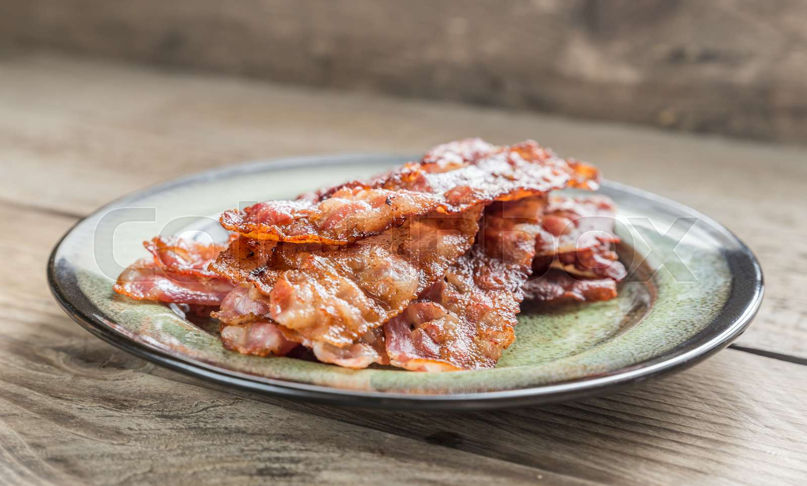 Stack of fried bacon strips on the plate | Stock image | Colourbox
