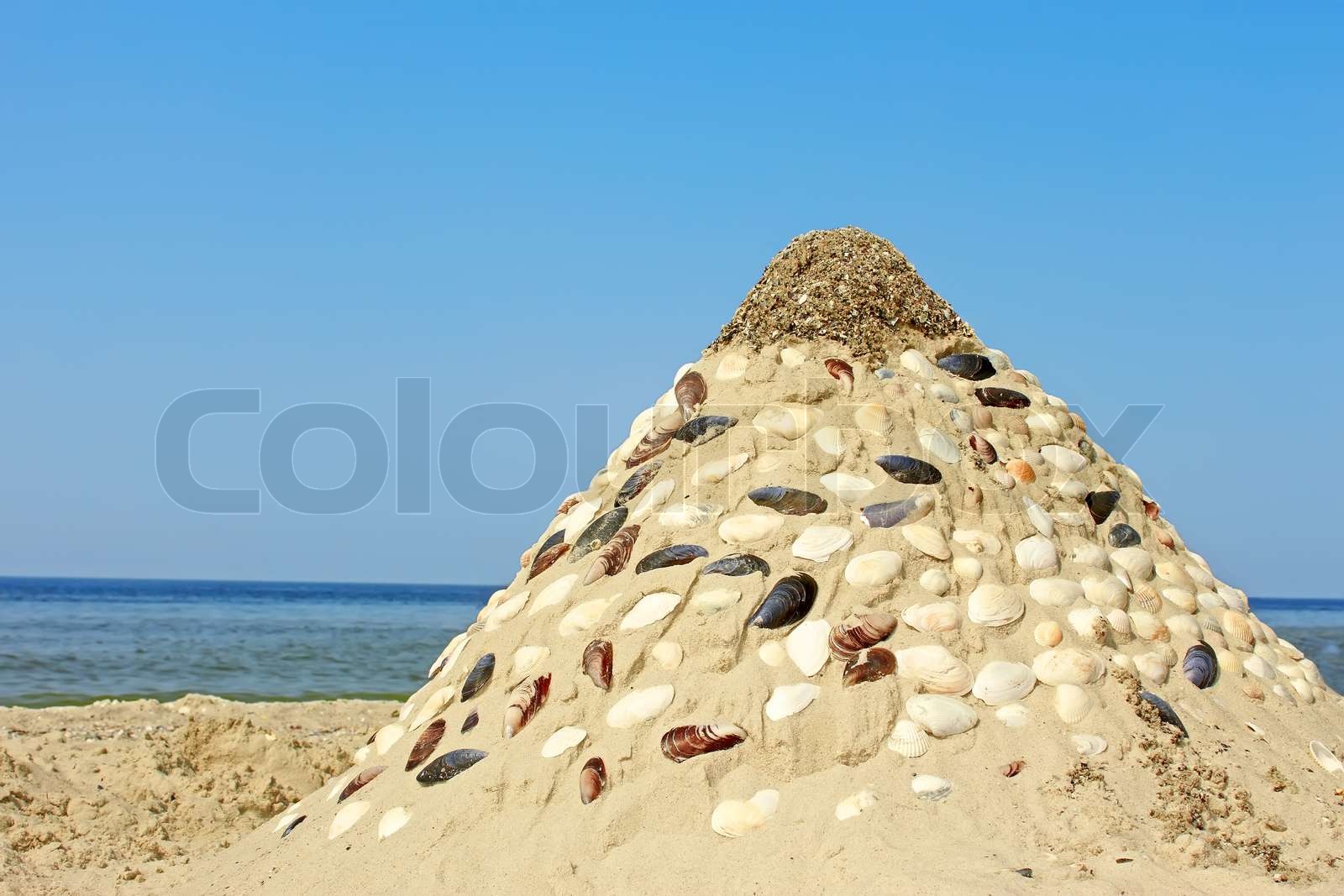 Pyramid of sand and shells on the sea beach | Stock image | Colourbox