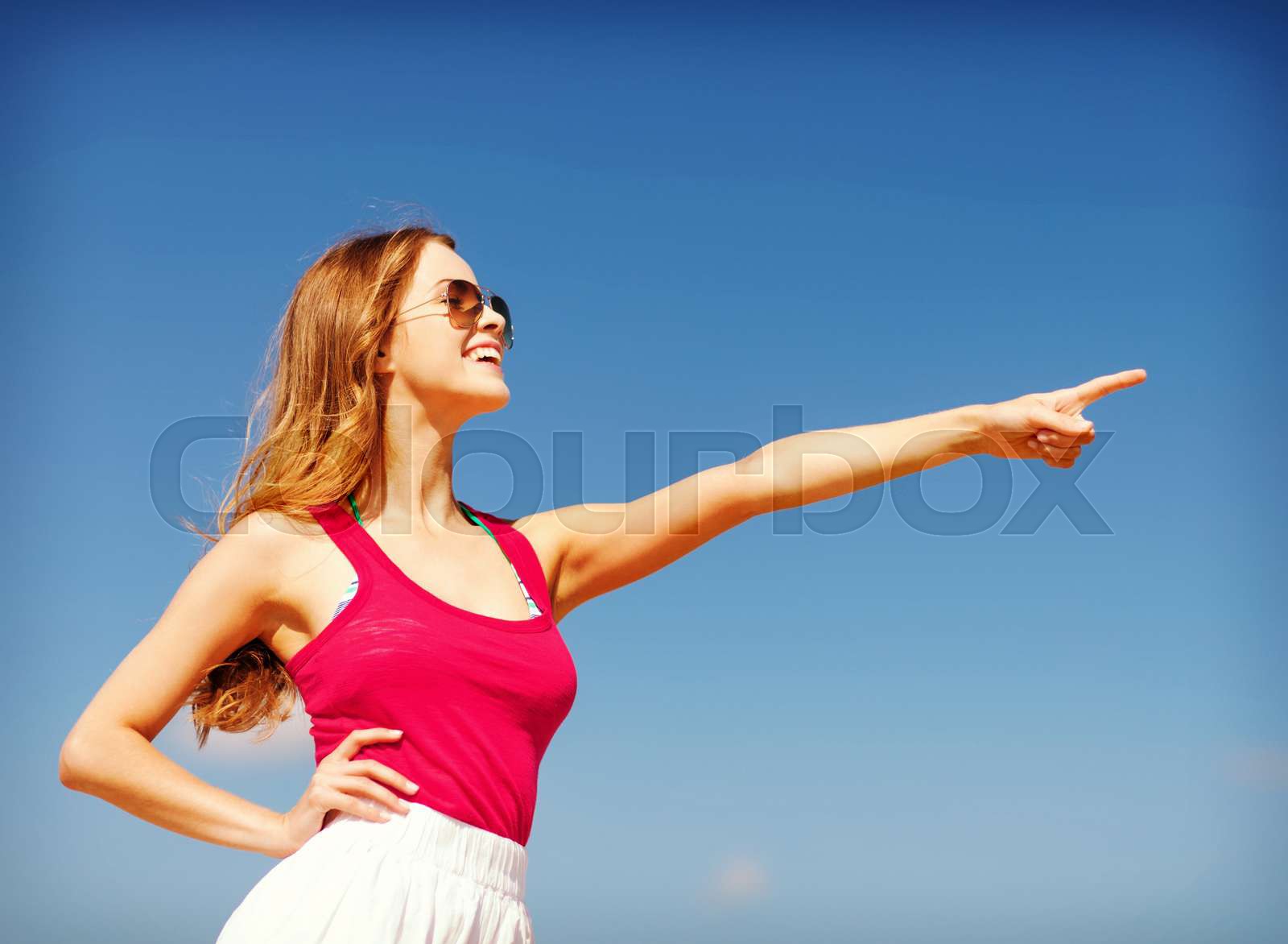 girl showing direction on the beach | Stock image | Colourbox