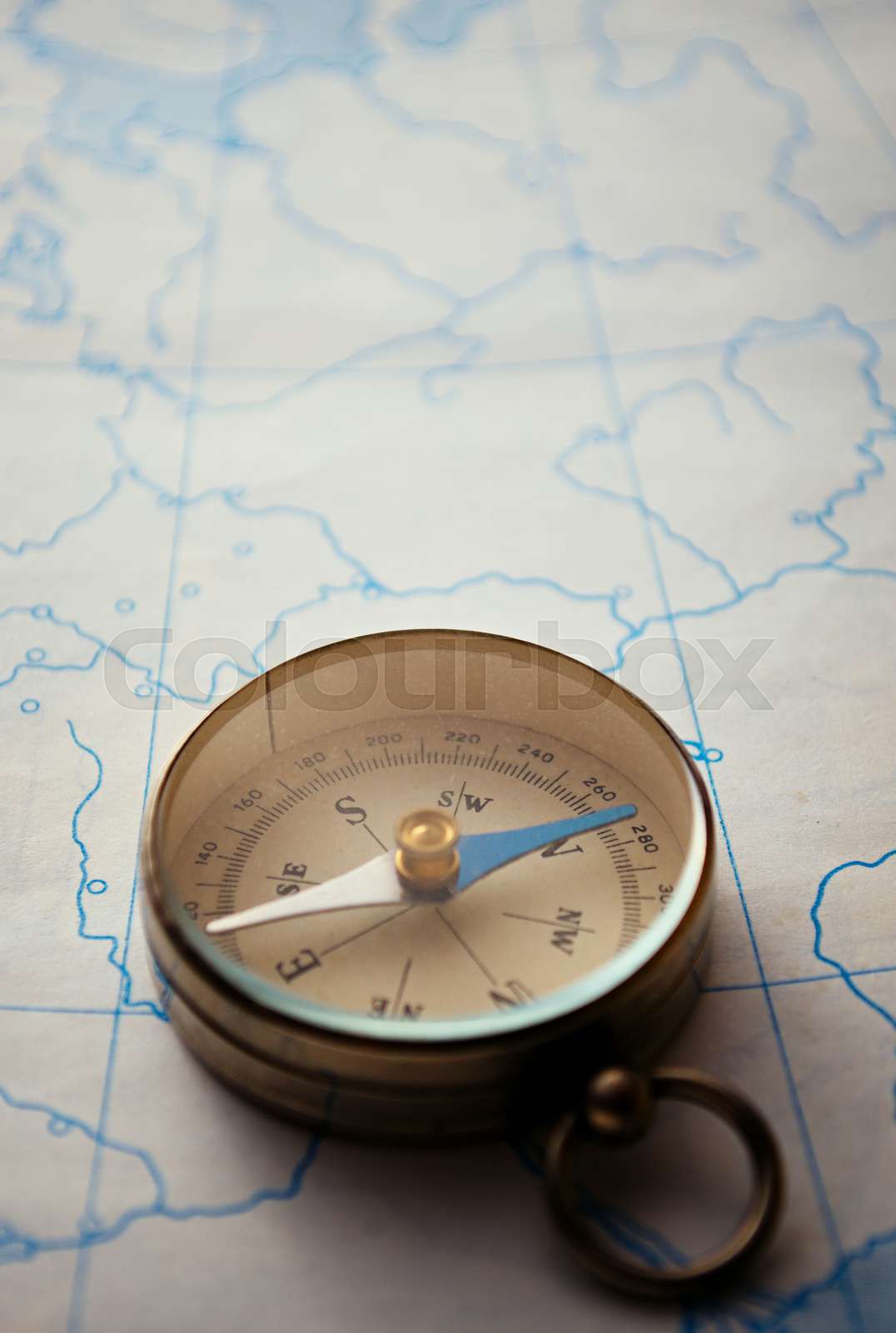Magnetic compass lying on a map | Stock image | Colourbox