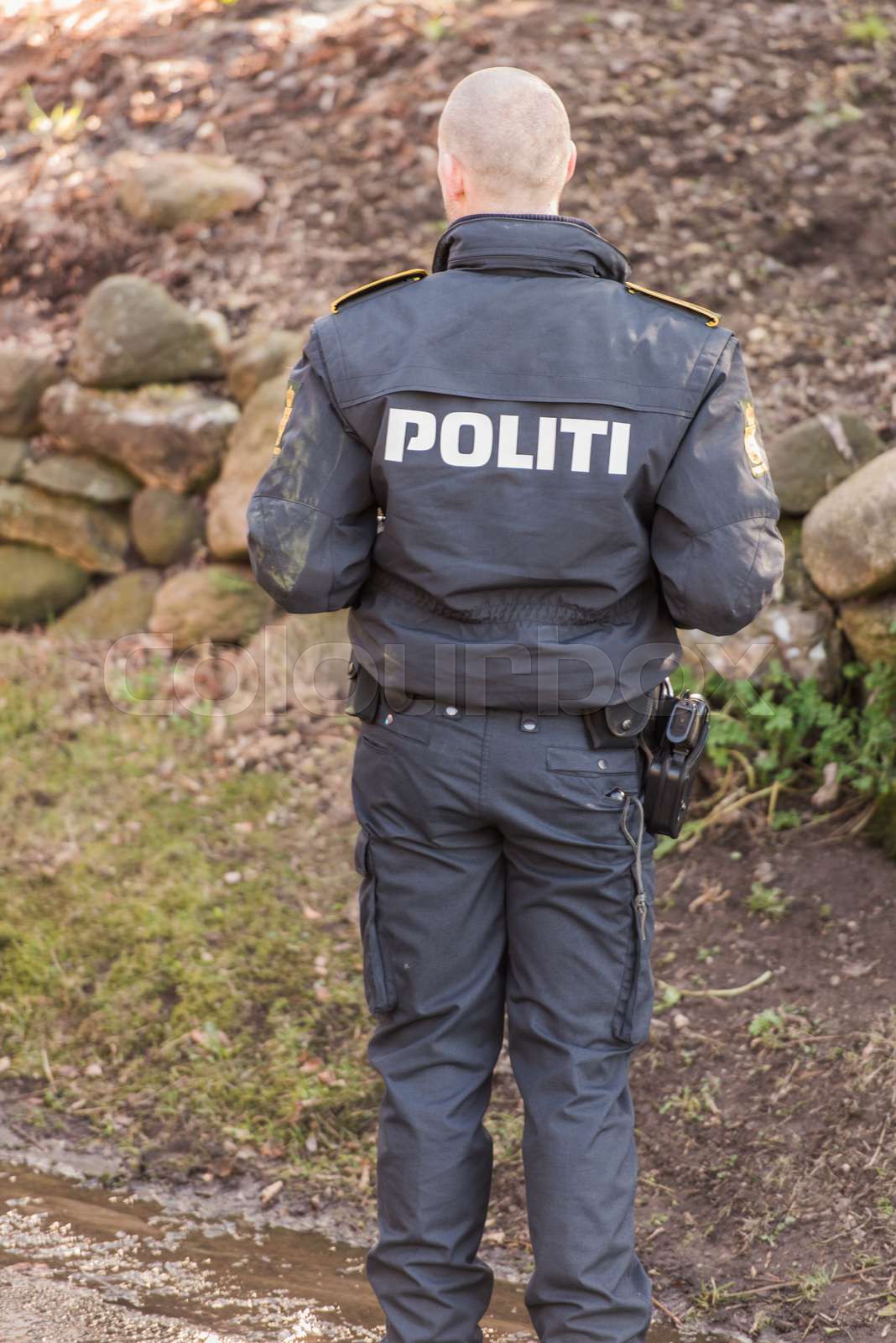 Dansk politibetjent set bagfra tæt på udendørs | Stock foto | Colourbox