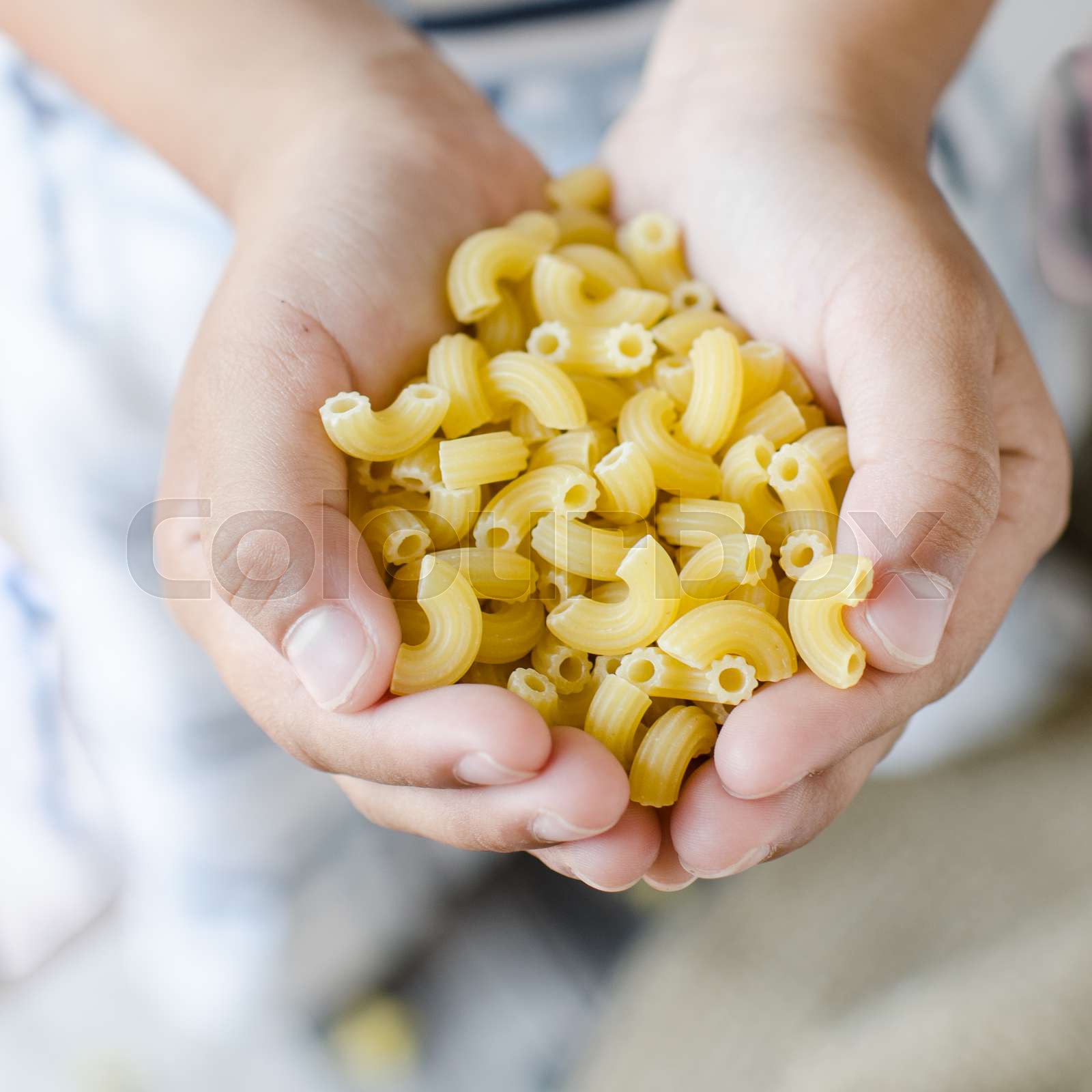 Italian Macaroni Pasta in child hand. | Stock image | Colourbox
