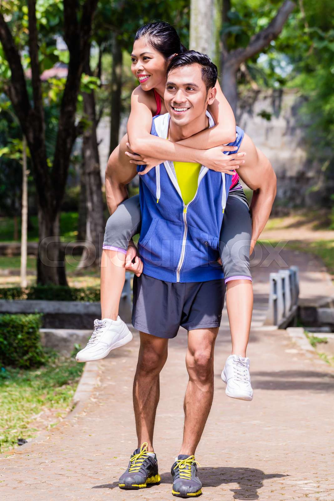 Asian man carrying his girlfriend piggyback for sport | Stock image ...