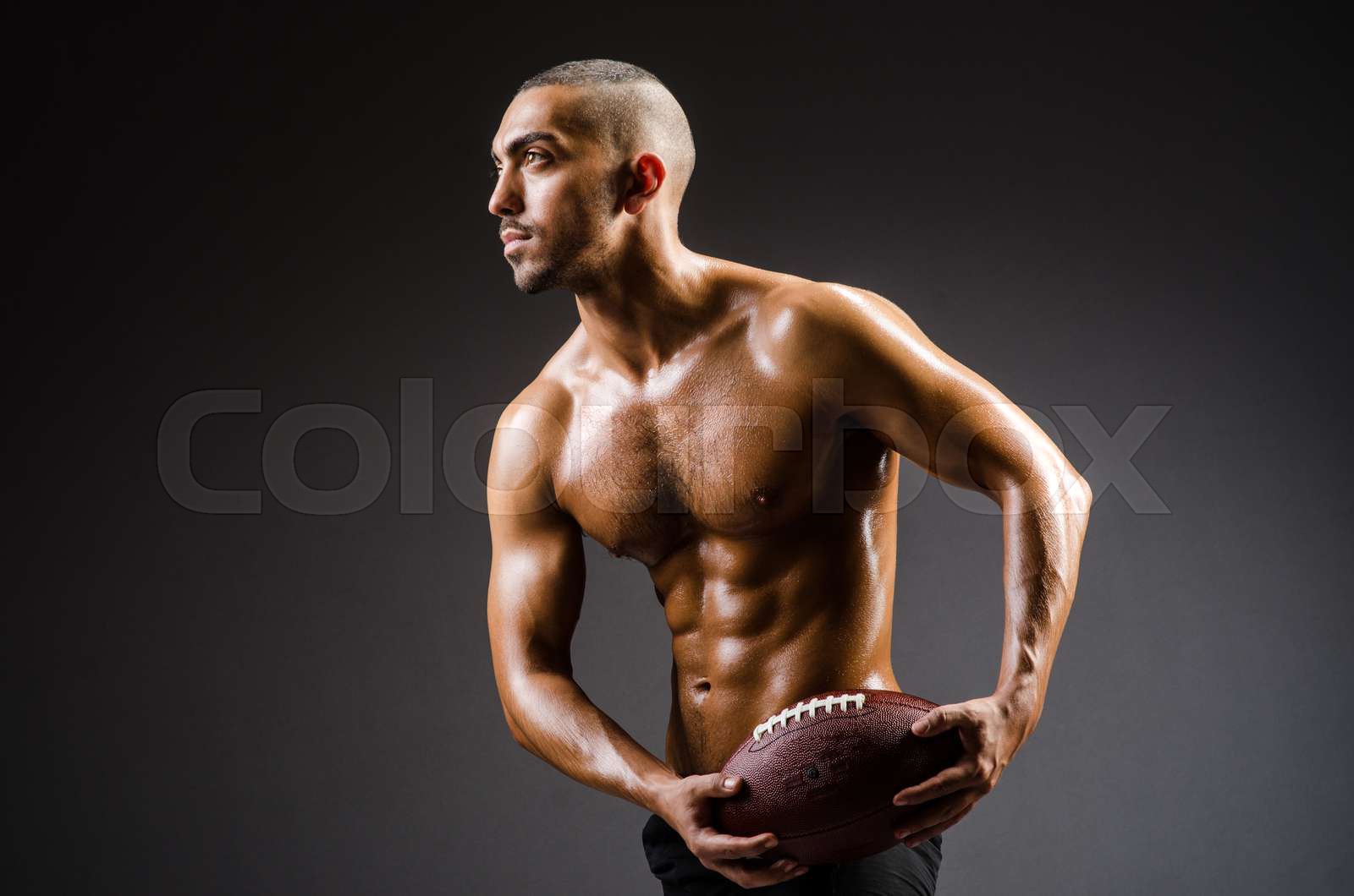 Muscular football player with ball | Stock image | Colourbox