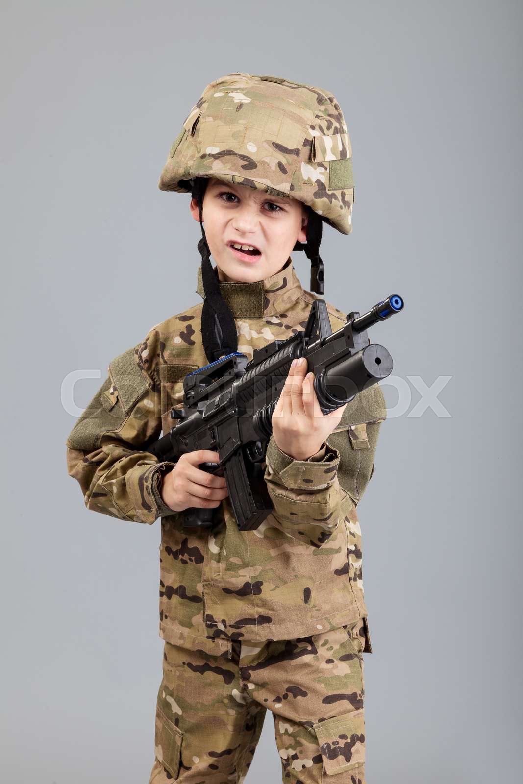 Young boy dressed like a soldier with rifle | Stock image | Colourbox