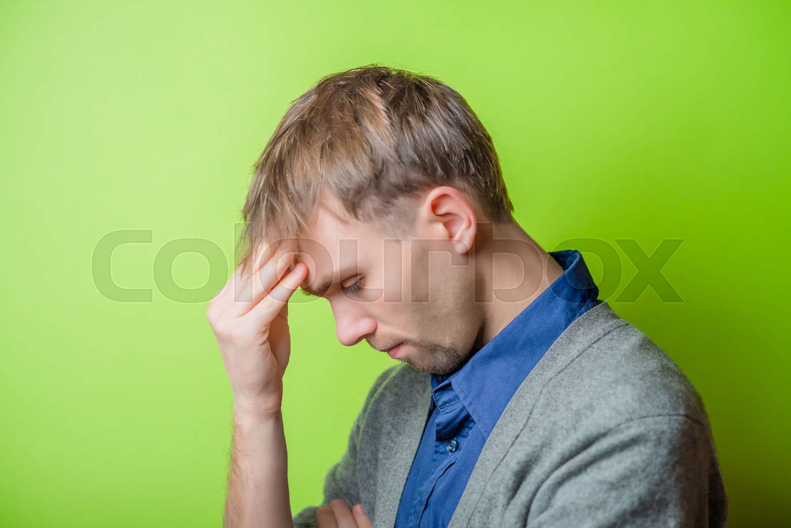 Upset man standing with his hand holding his forehead | Stock image ...