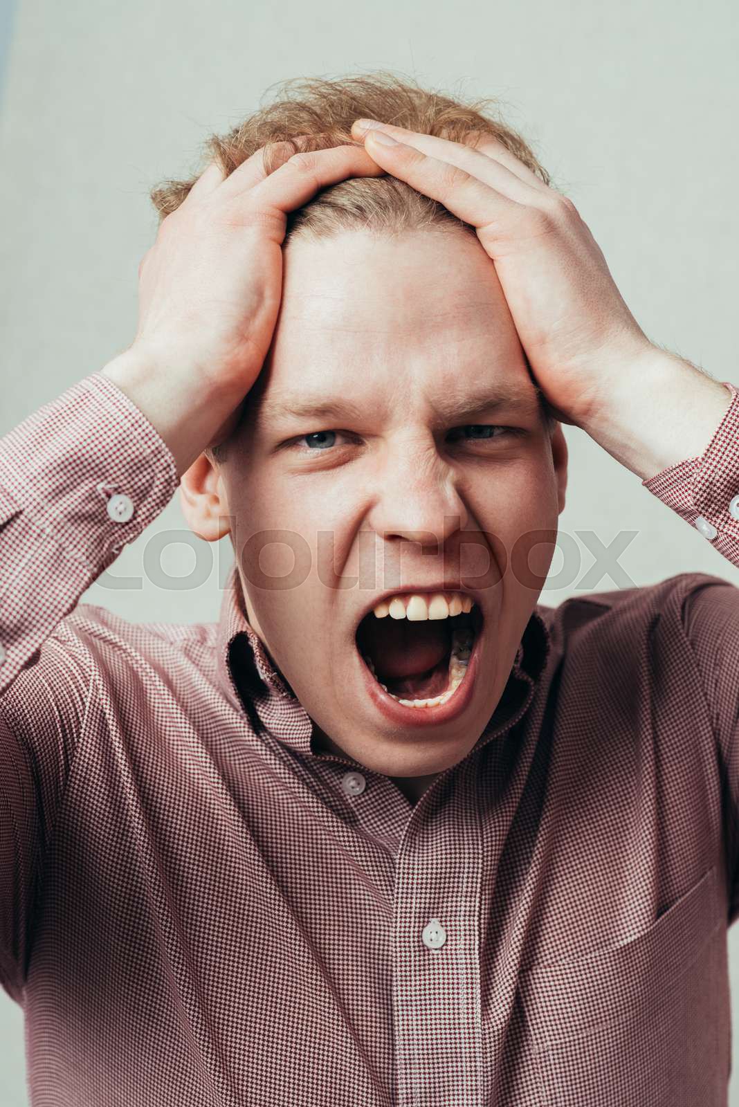 man holding his head and screaming | Stock image | Colourbox