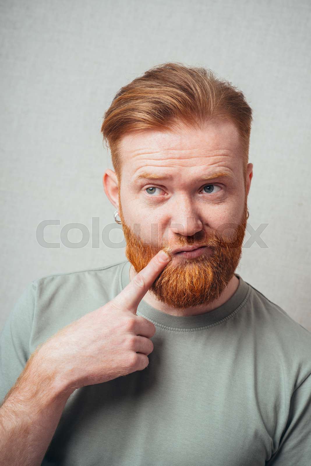bearded man put his finger to his cheek | Stock image | Colourbox