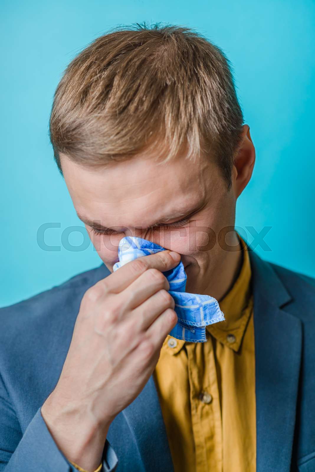 young man blows his nose into a handkerchief | Stock image | Colourbox