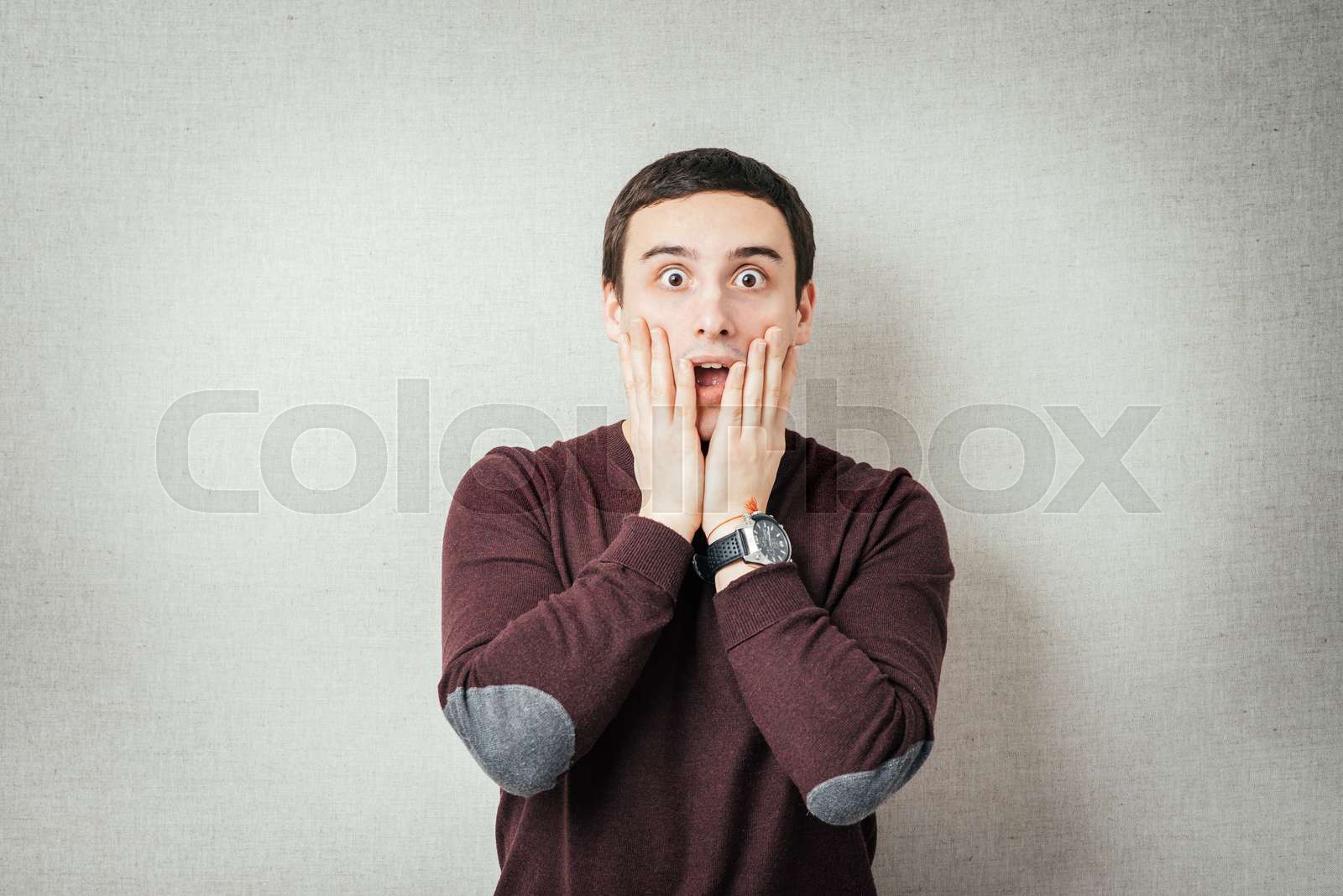young man in shock with hands on face | Stock image | Colourbox