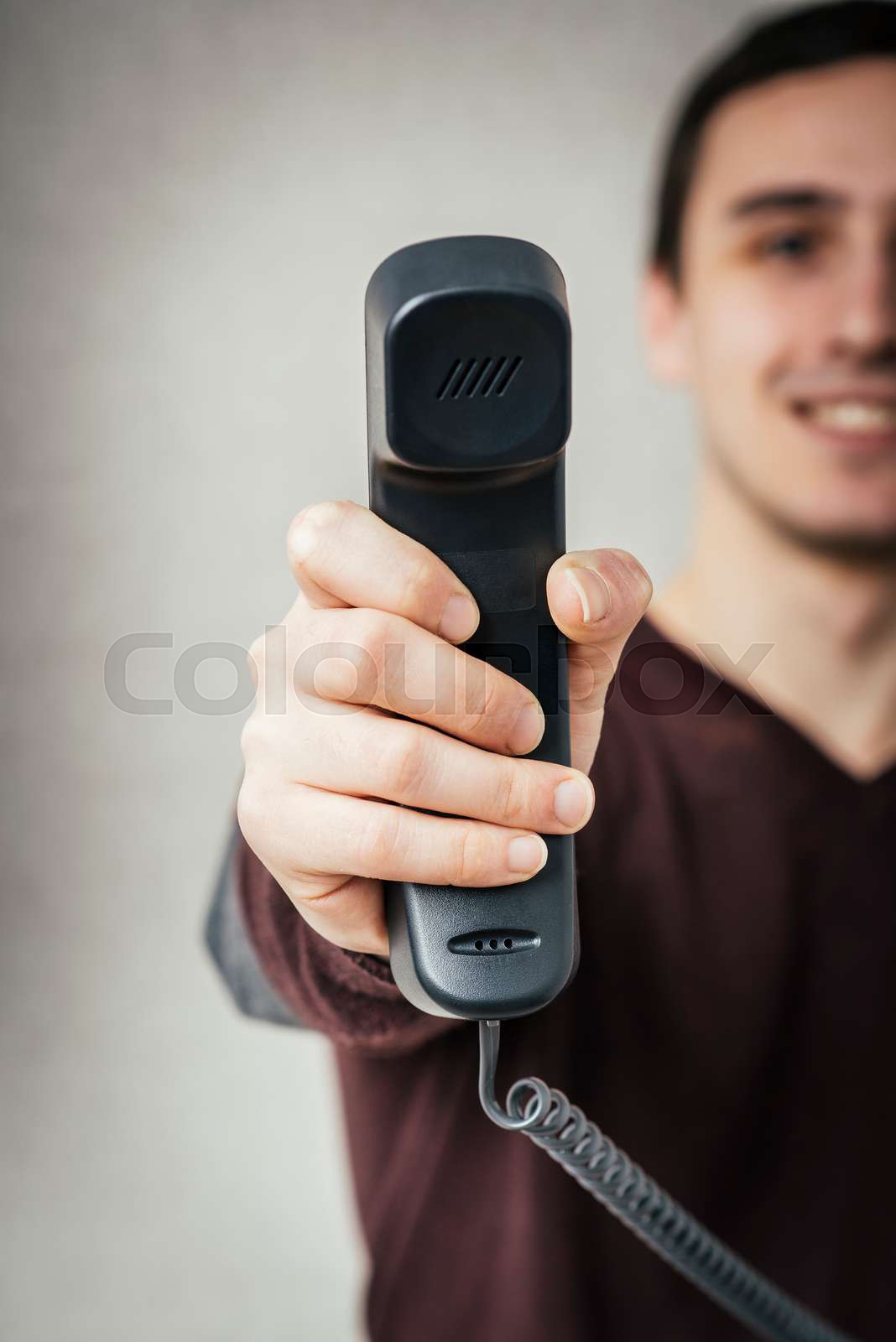Man holding a landline telephone receiver | Stock image | Colourbox
