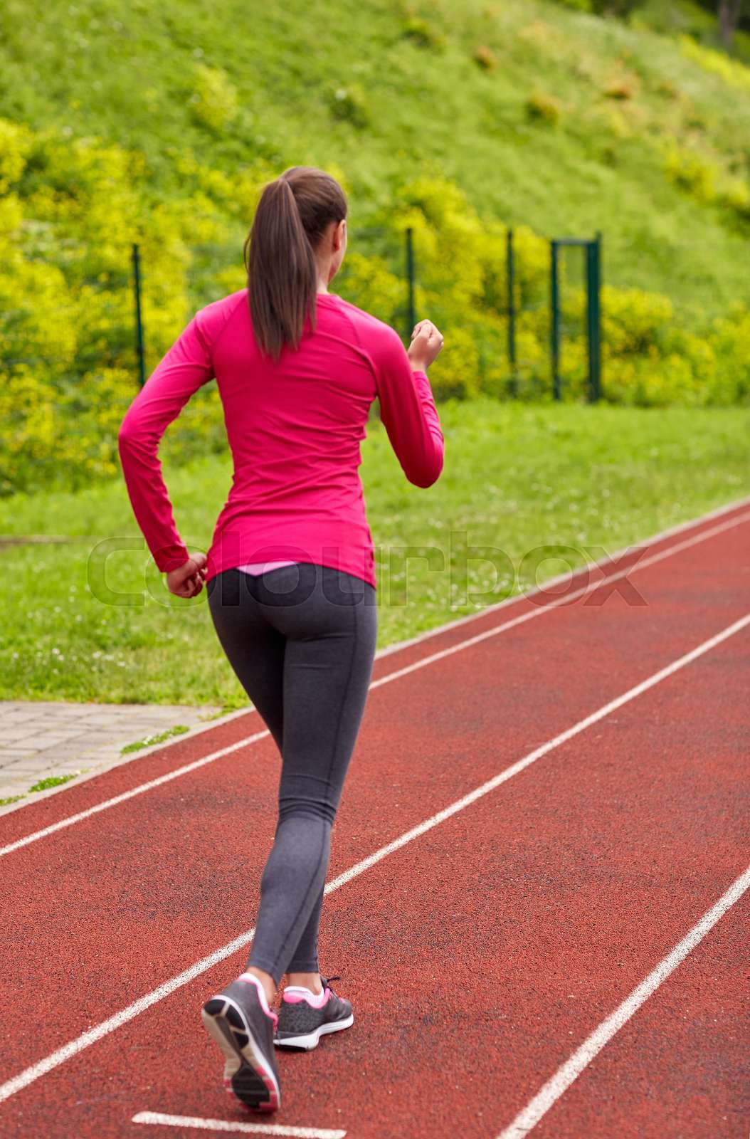 woman running on track outdoors from back | Stock image | Colourbox