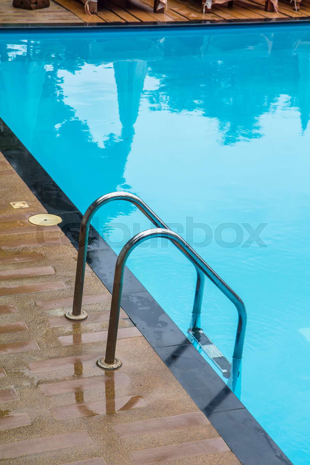 Blue swimming pool with teak wood flooring stripes summer vacation ...