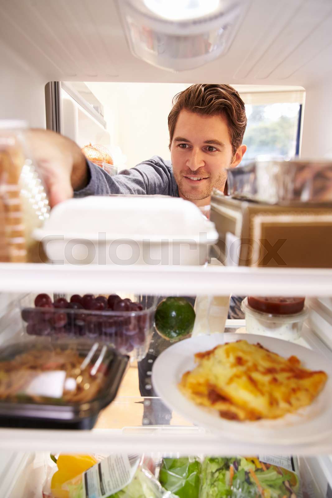 Man Looking Inside Fridge Filled With Food | Stock image | Colourbox