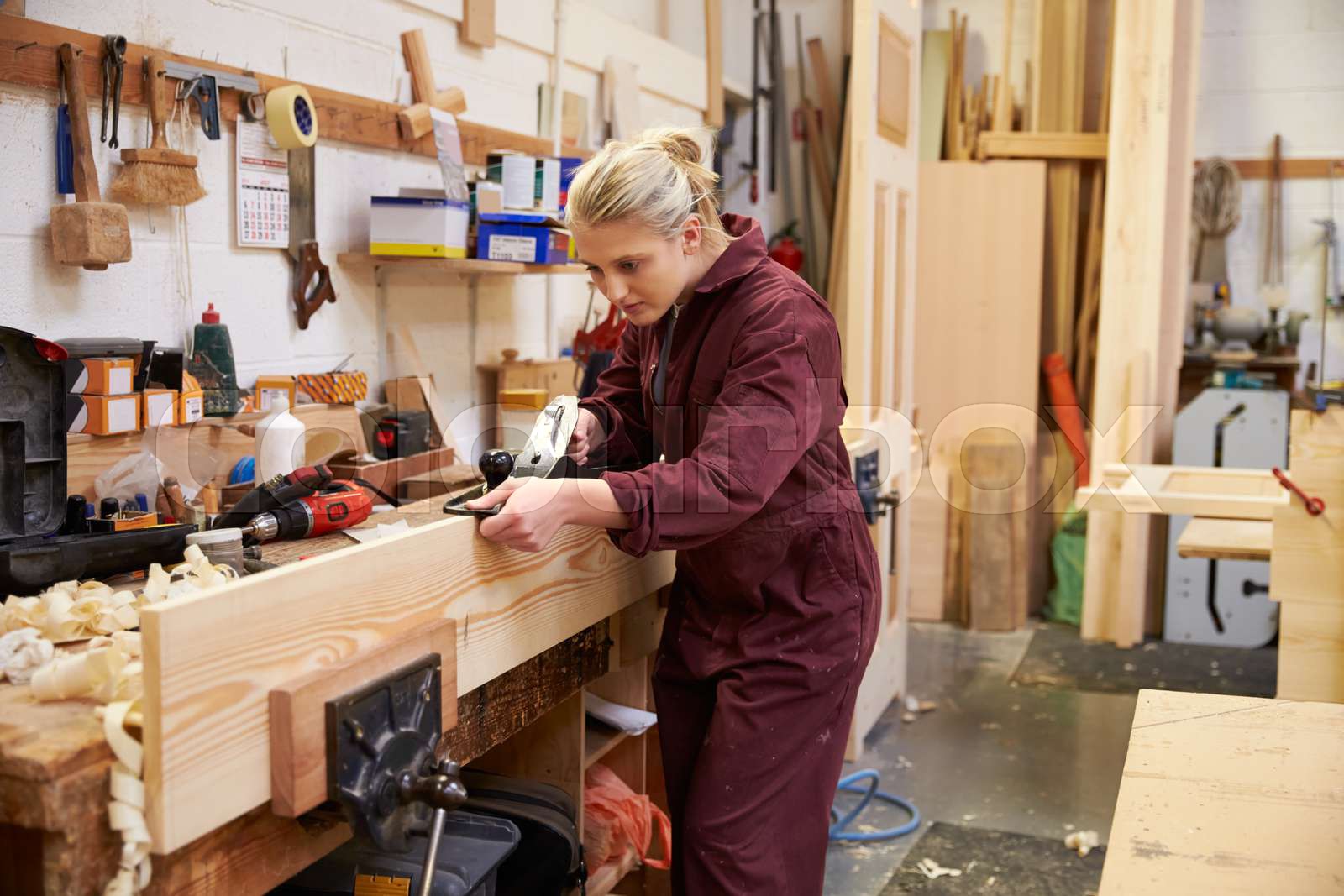 Female Apprentice Planing Wood In Carpentry Workshop | Stock image ...