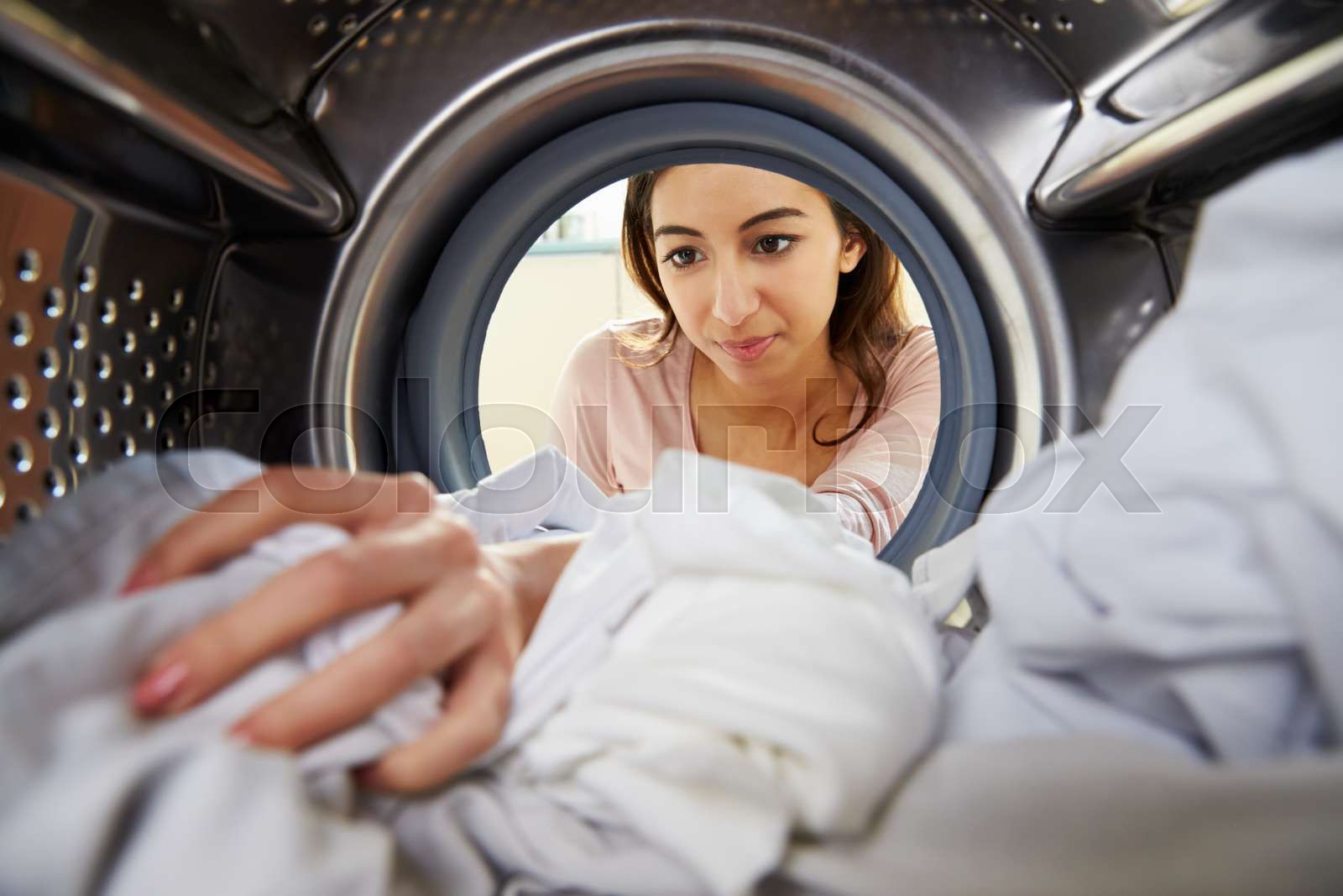 Woman Doing Laundry Reaching Inside Washing Machine | Stock image ...