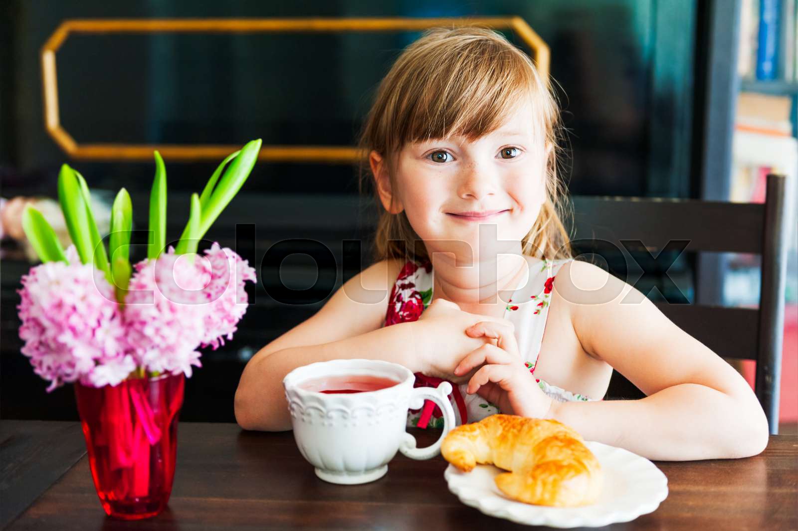 Adorable little girl drinking tea at home | Stock image | Colourbox