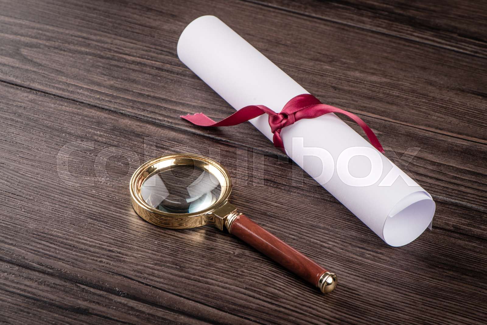 Wrapped paper sheets and magnifying glass | Stock image | Colourbox