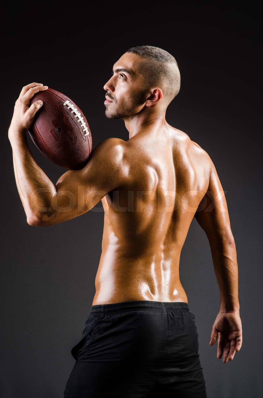 Muscular football player with ball | Stock image | Colourbox