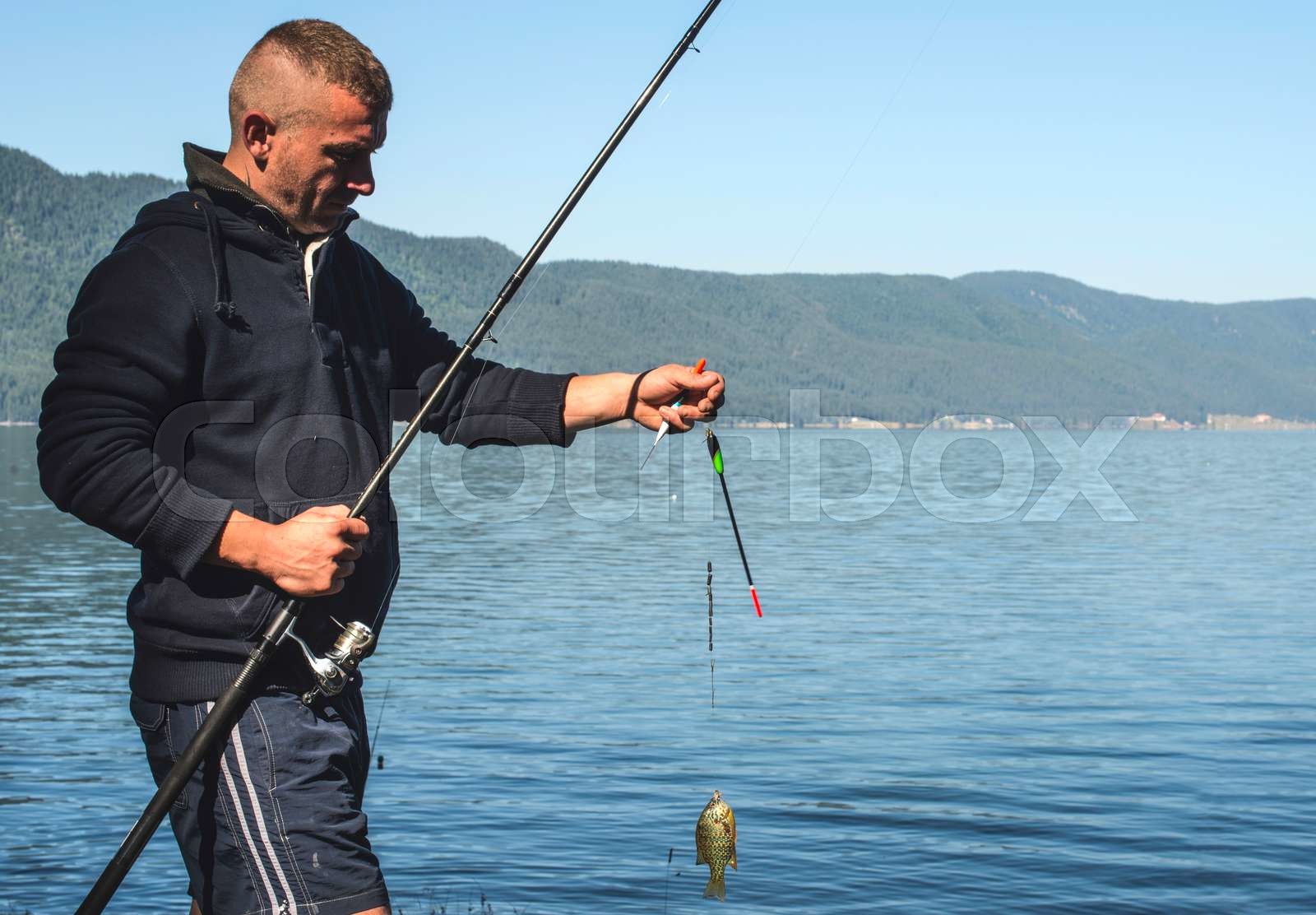 Fisherman caught a fish | Stock image | Colourbox
