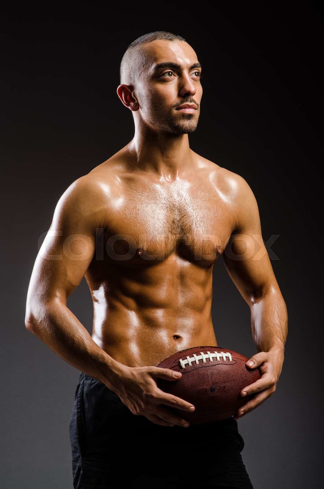 Muscular football player with ball | Stock image | Colourbox