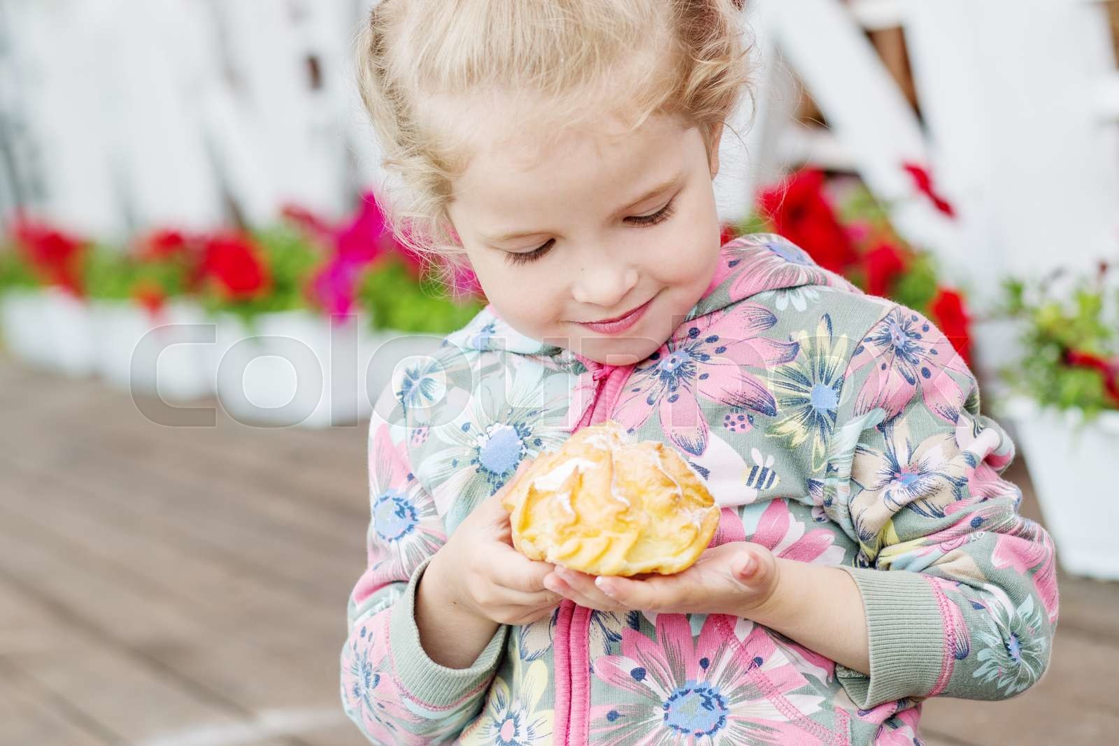 cute little girl eating eclair | Stock image | Colourbox