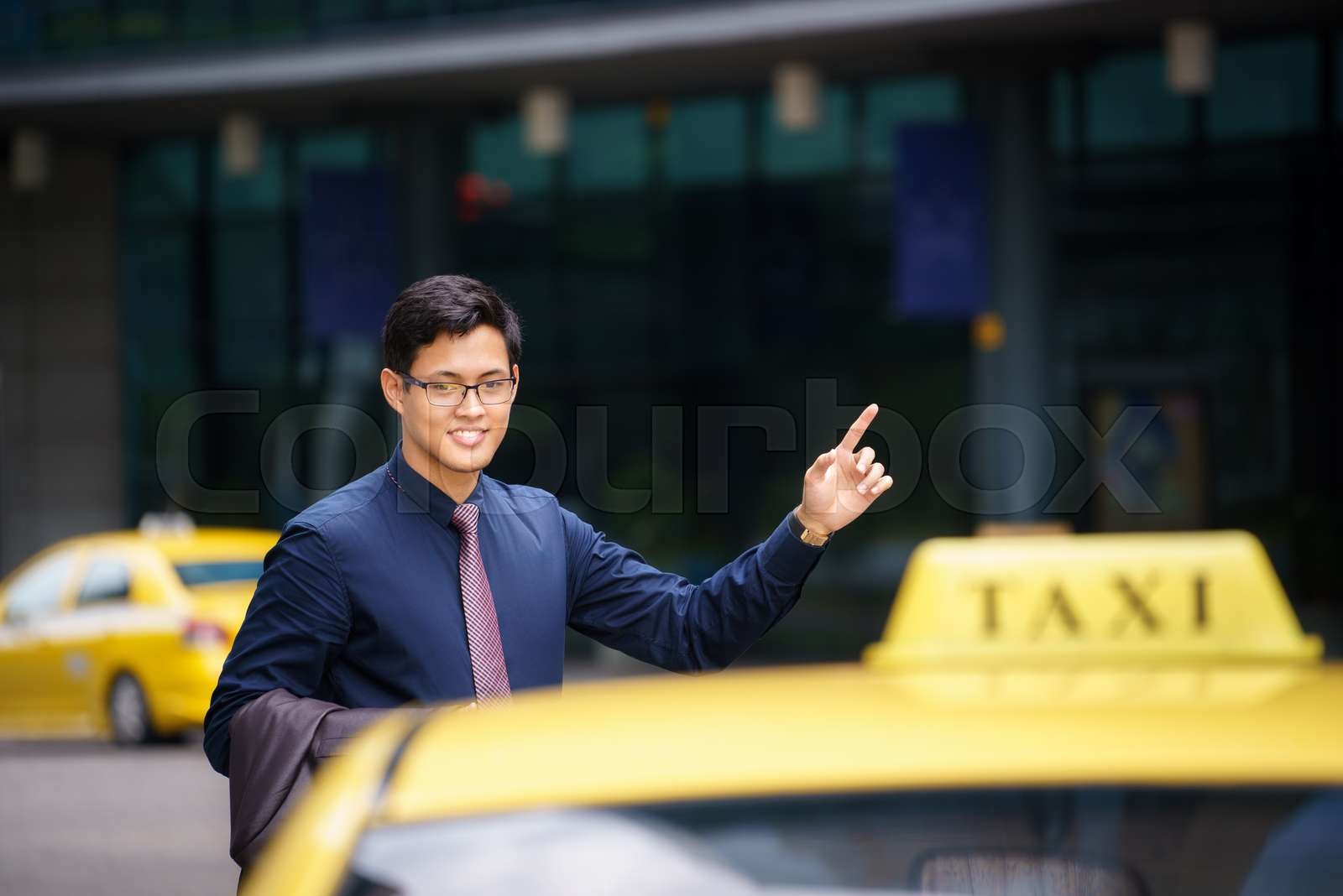asian businessman calling taxi car leaving work | Stock image | Colourbox
