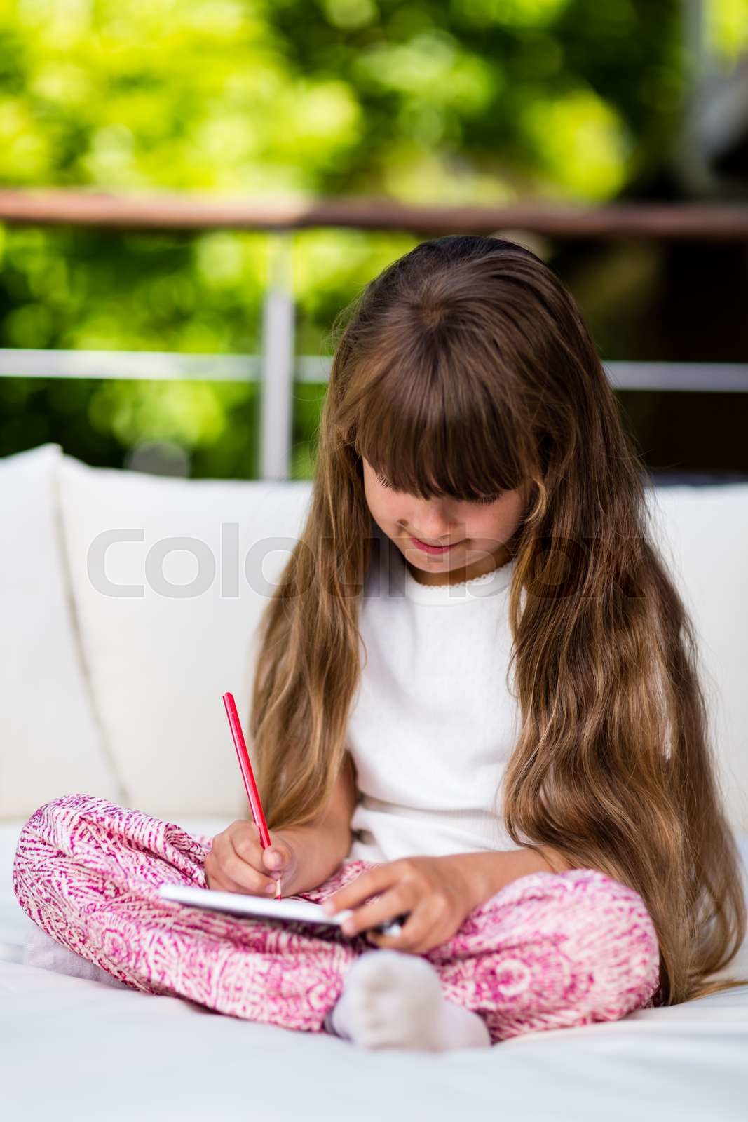 Girl writing at notepad | Stock image | Colourbox