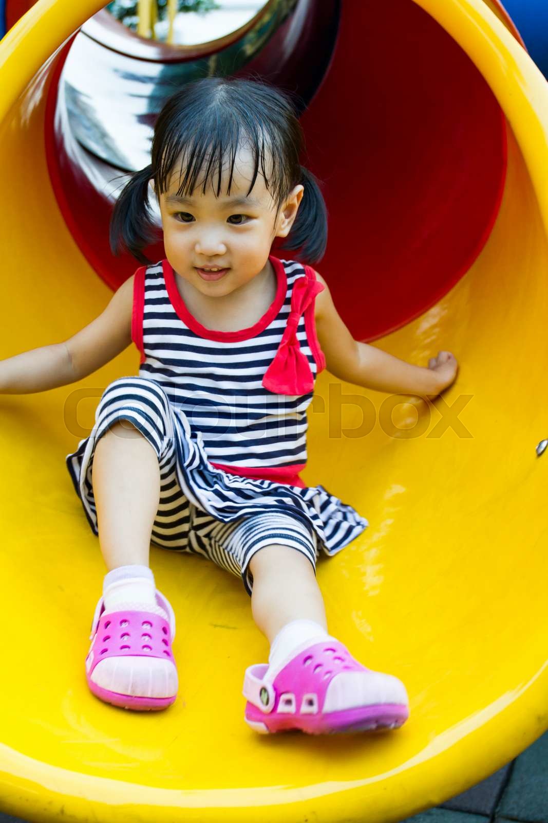 Asian kid sliding on Playground | Stock image | Colourbox