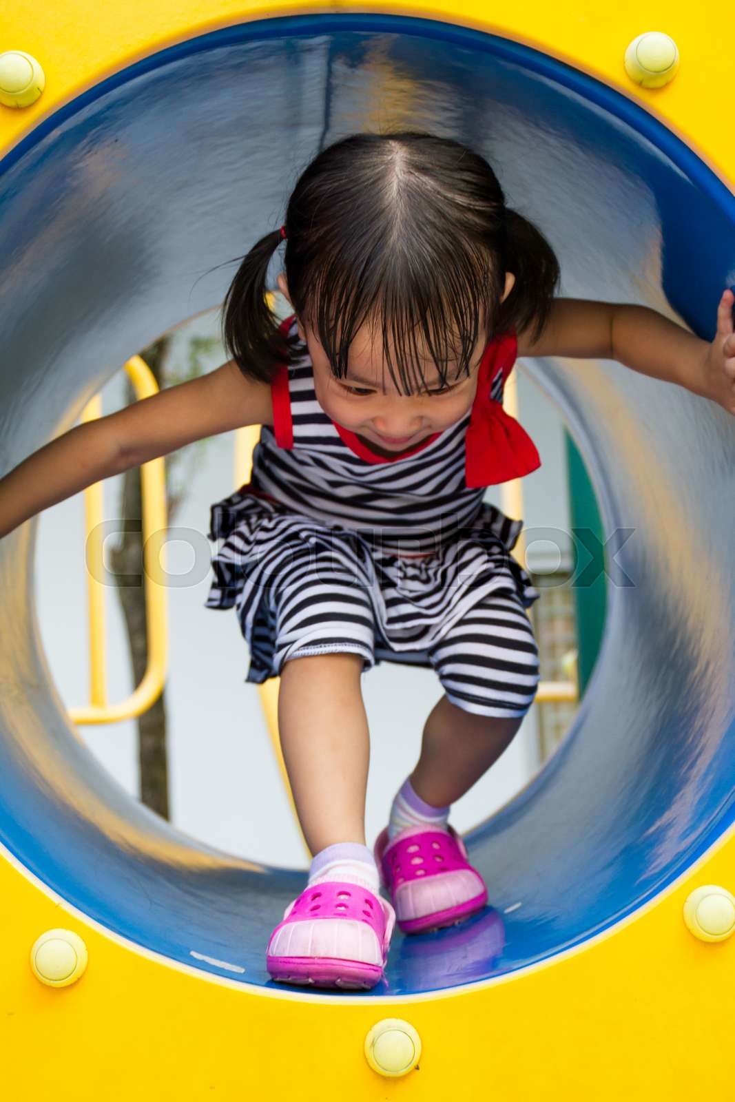 Asian Kid Crawling on Playground Tube | Stock image | Colourbox