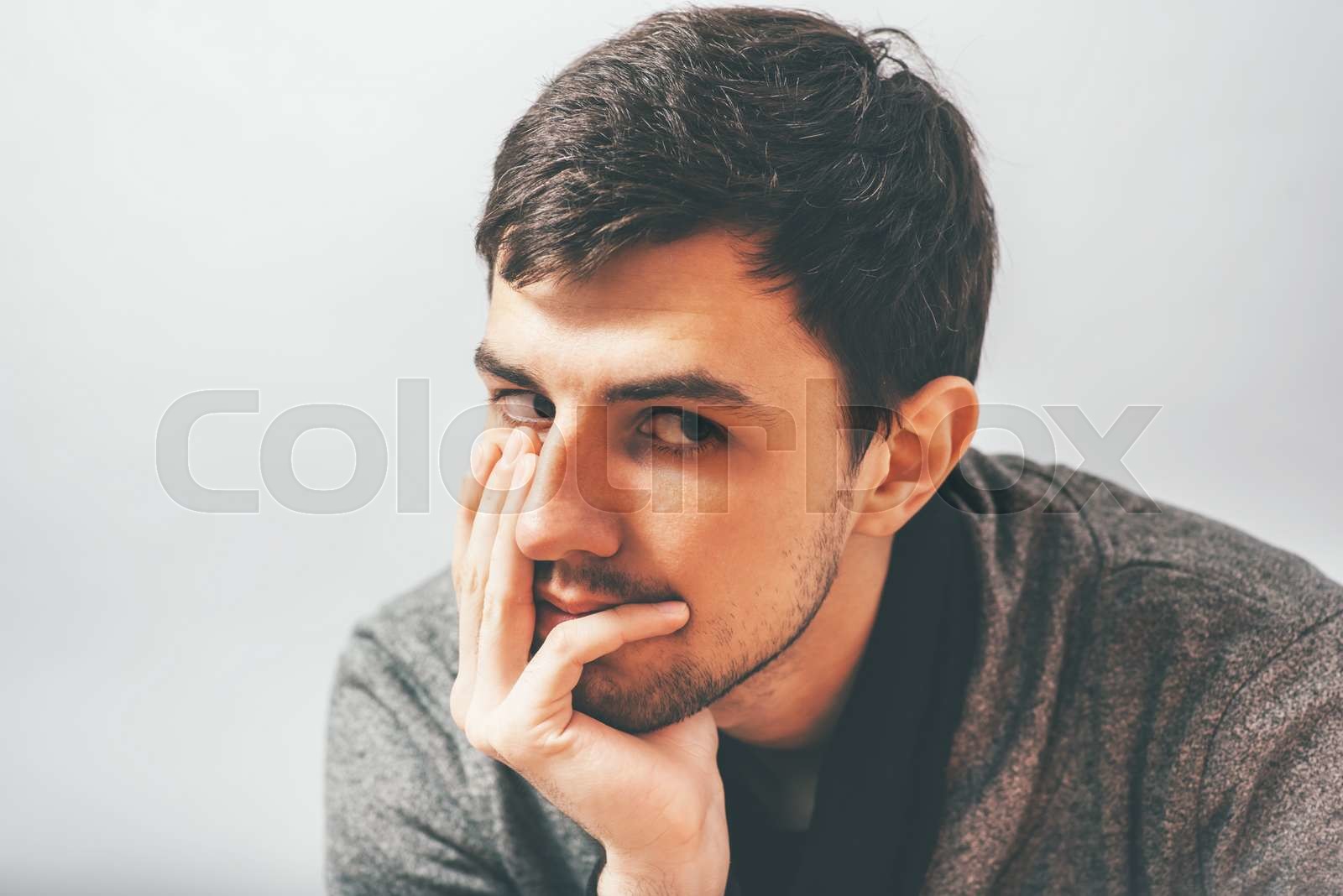 guy props chin in his hand | Stock image | Colourbox