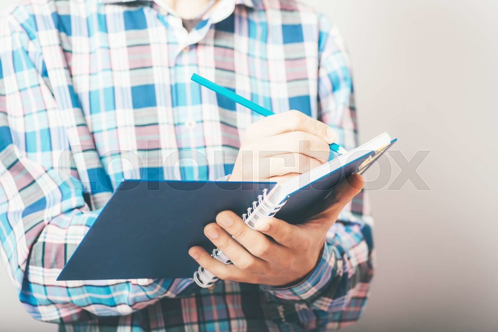 man writing in a notebook | Stock image | Colourbox