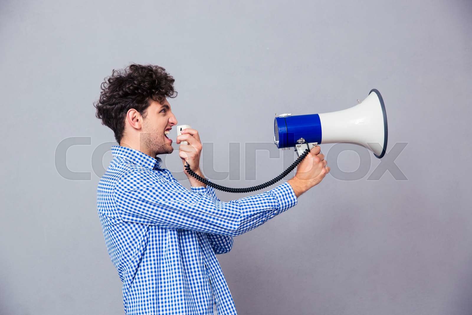 Casual man shouting on megaphone | Stock image | Colourbox