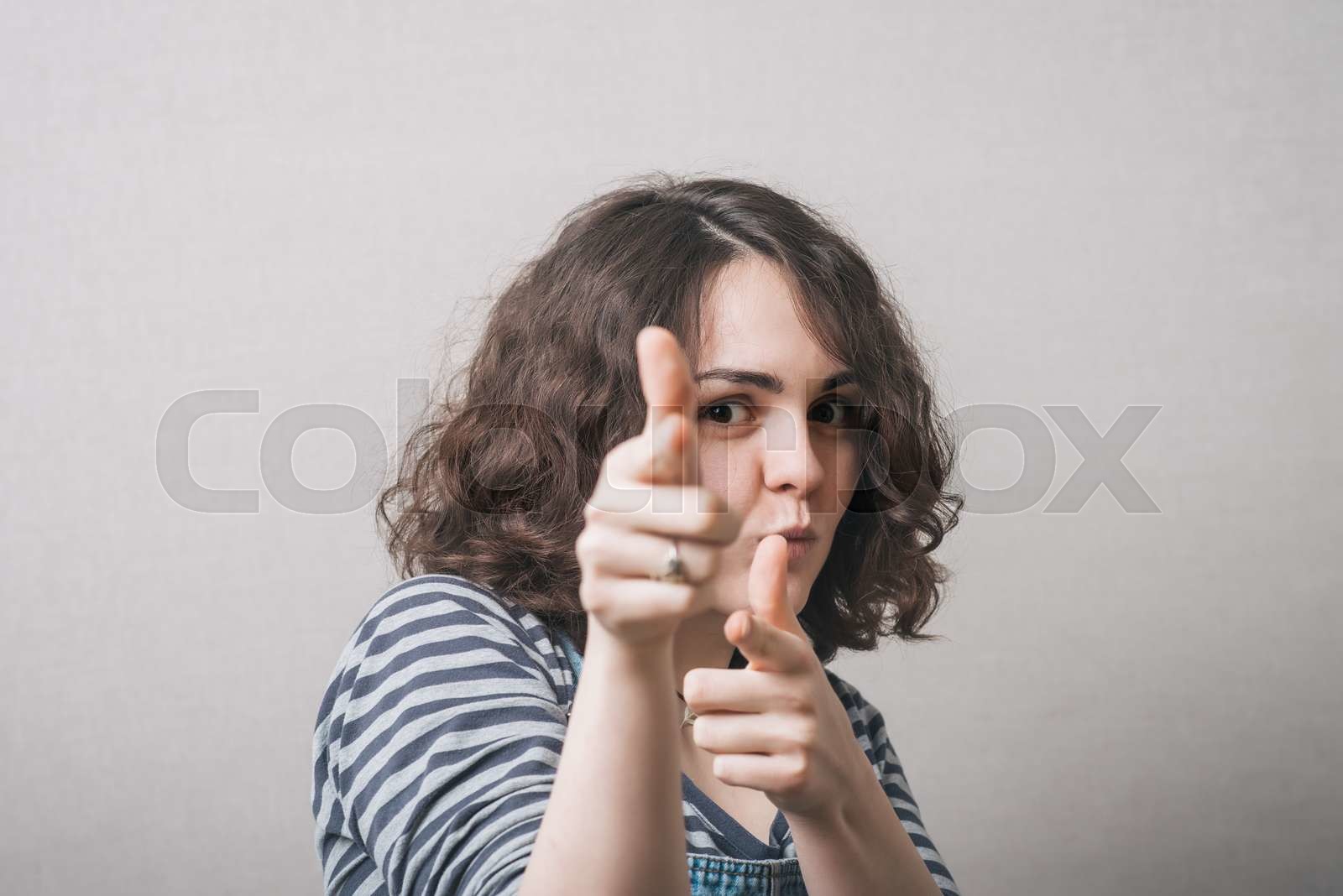 A woman shows a finger forward | Stock image | Colourbox