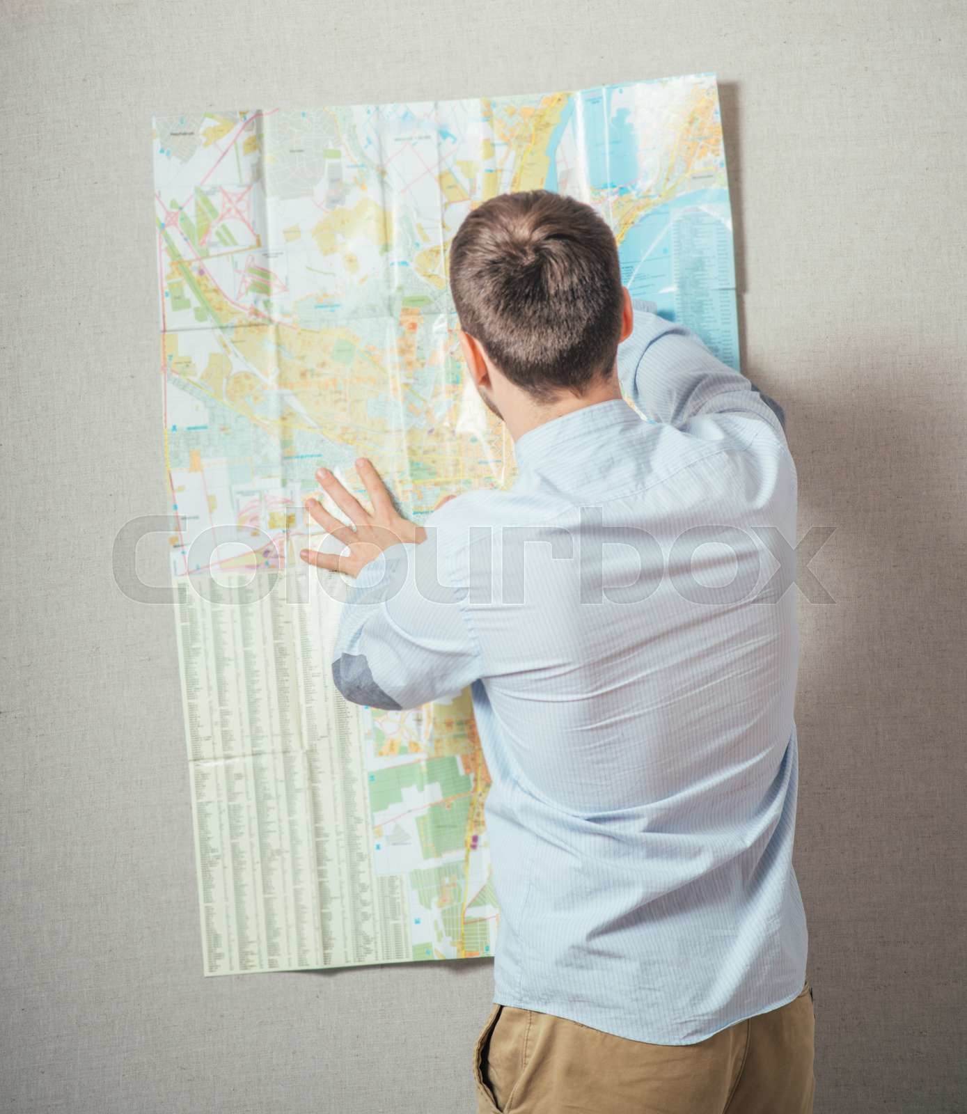 Tourist man looking at map against | Stock image | Colourbox