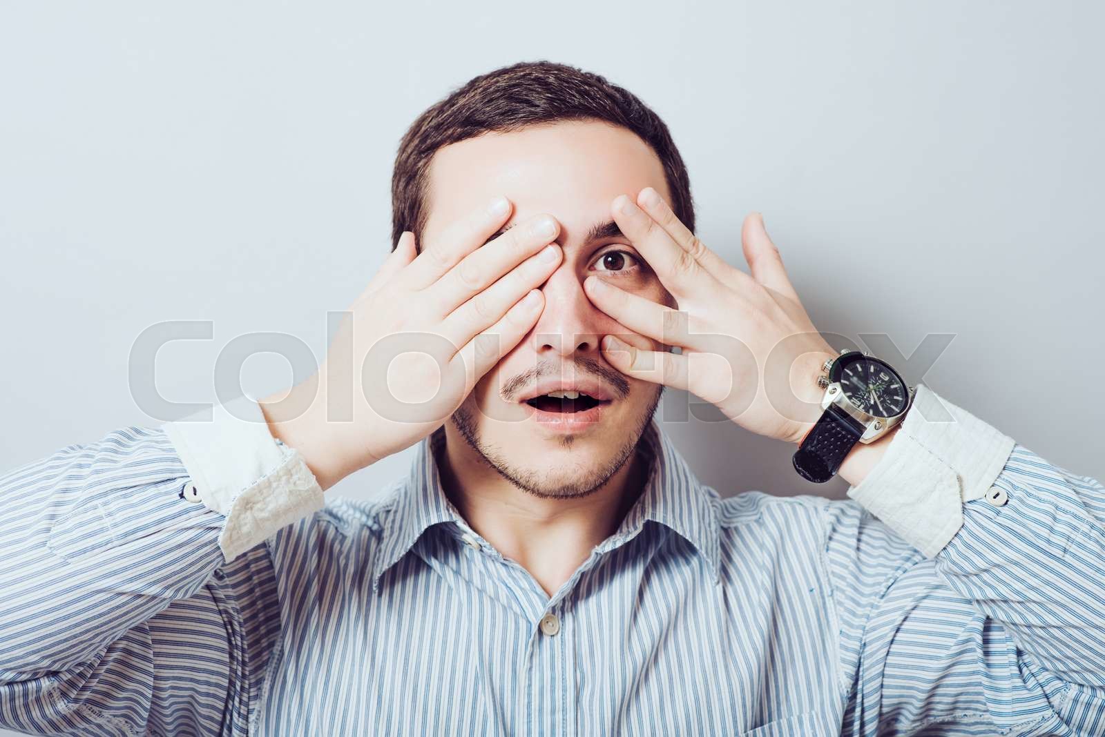 Watch Through his Fingers. | Stock image | Colourbox