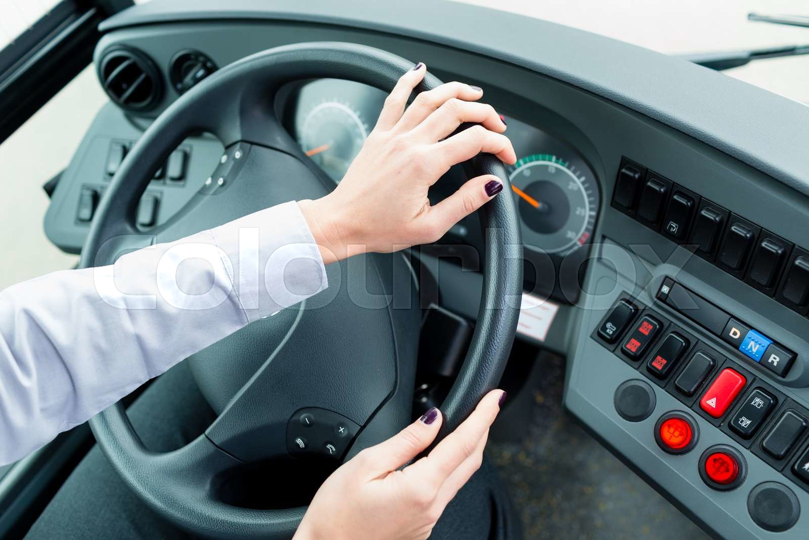 Bus driver in cockpit at the wheel driving | Stock image | Colourbox