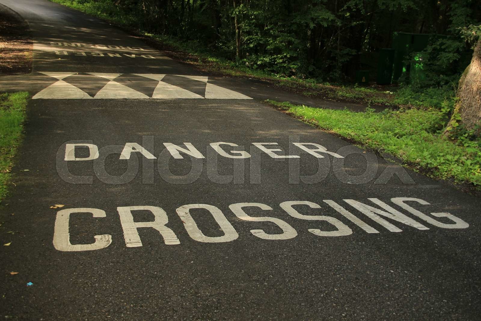 Attention, speed bump and the text, danger crossing at the asphalt in ...