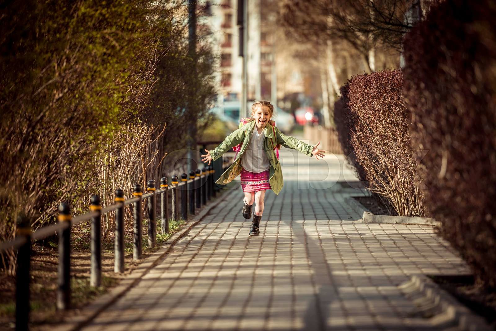 happy little girl running from school | Stock image | Colourbox