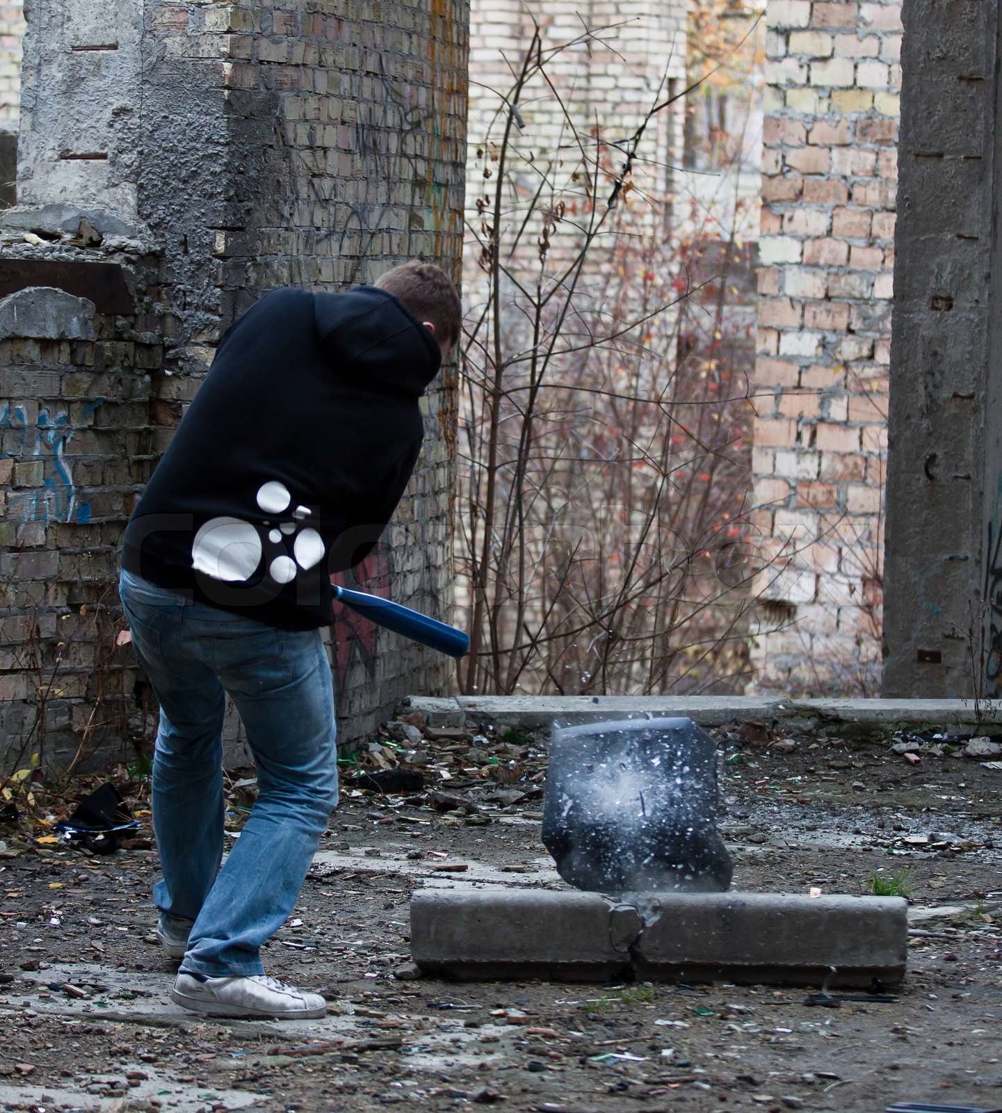 Boy with anger destroying his television set, with lots of cracks and ...
