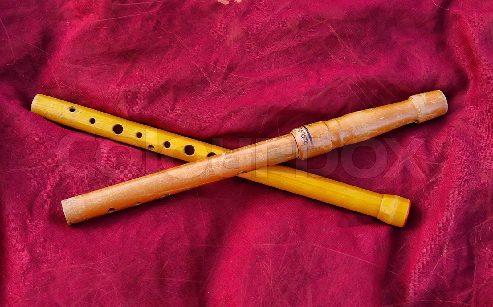 Two wooden old flutes on a rough red fabric | Stock image | Colourbox