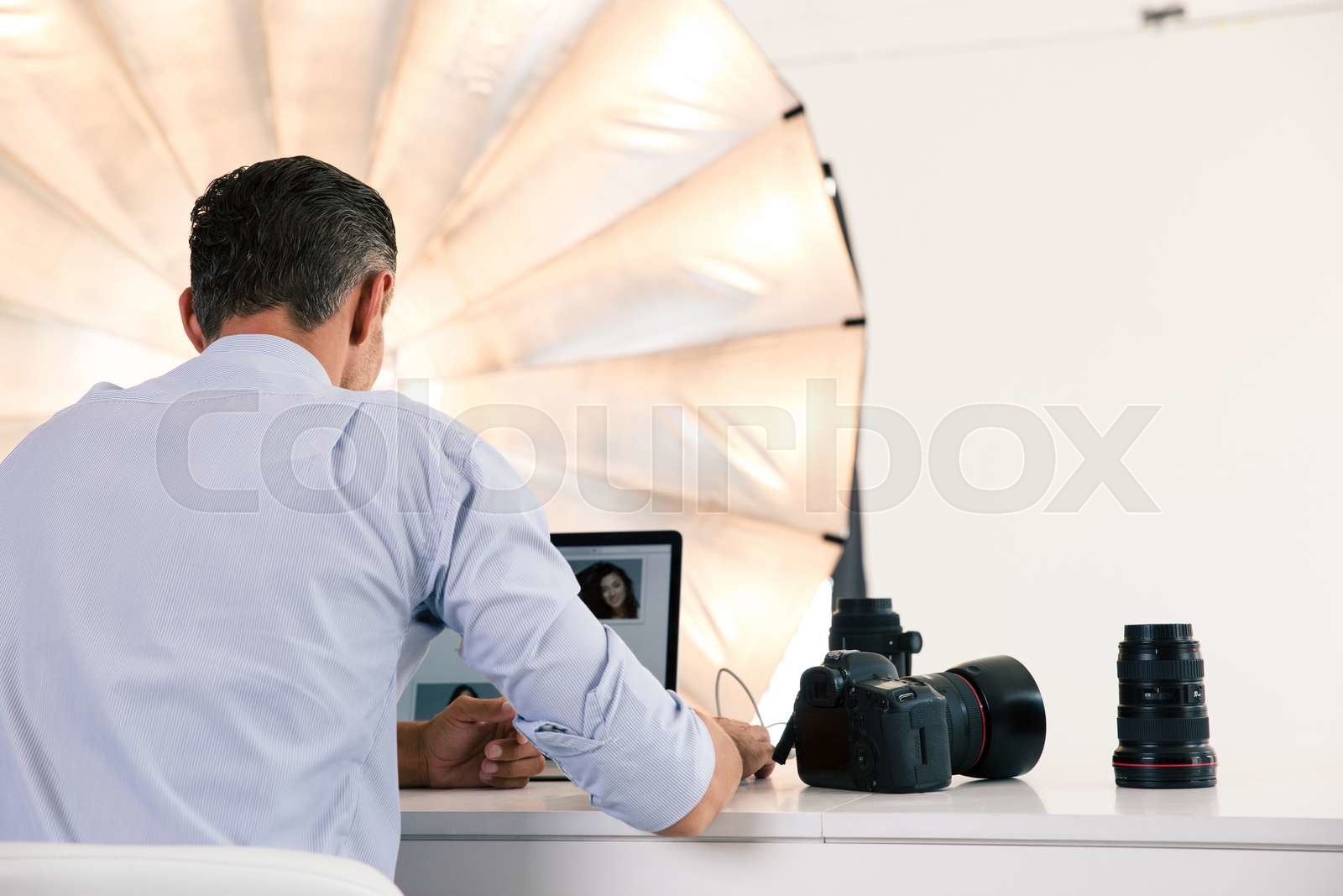 Back view portrait of photographer using laptop | Stock image | Colourbox